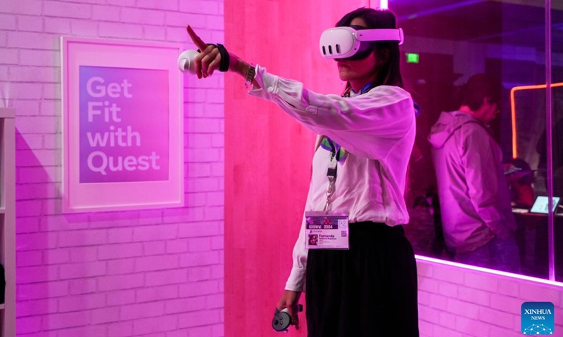 Visitors try VR devices during extended reality (XR) experience exhibition in Austin, U.S ...