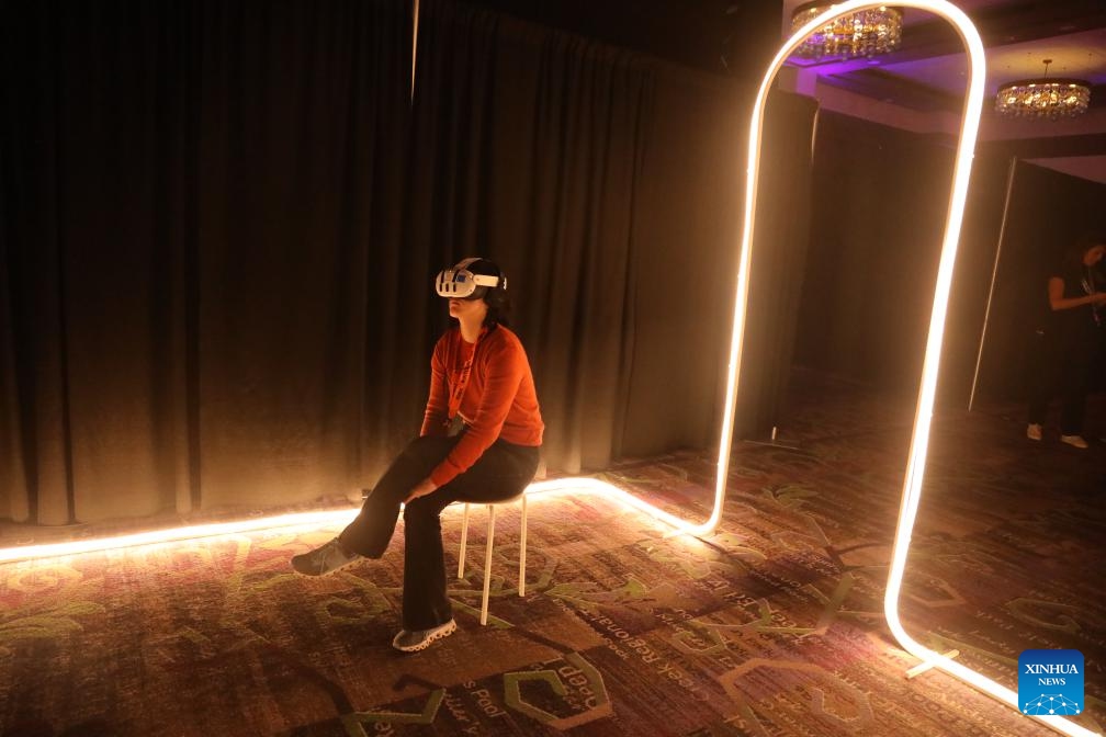 Visitors try VR devices during extended reality (XR) experience exhibition in Austin, U.S ...