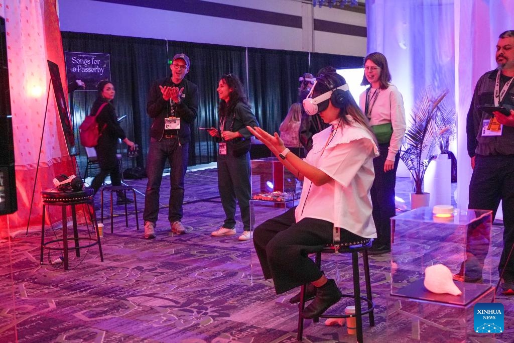 Visitors try VR devices during extended reality (XR) experience ...