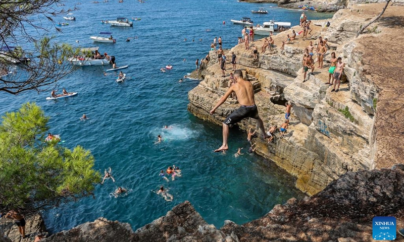 People dive into sea to cool off at Seagull's Rocks Beach in Croatia ...