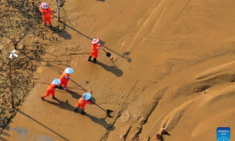 Workers clearing silt at riverside in Nanning, S China's Guangxi ...