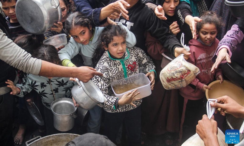 Displaced Palestinians get food aid from local community kitchen ...