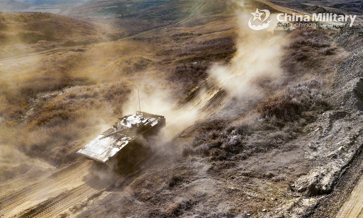 Armored vehicles run in muddy field - Global Times