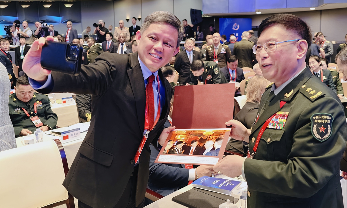 Chinese military expert presents a group photo to Singapore's minister ...