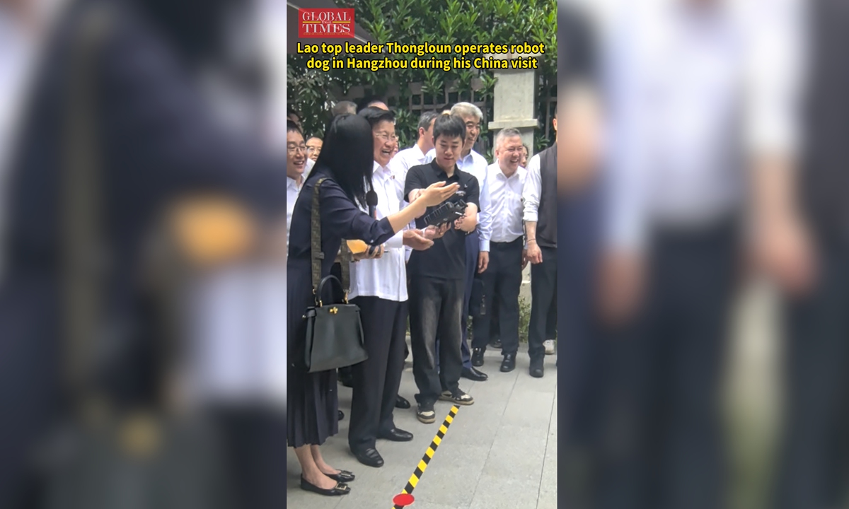 Lao top leader Thongloun operates robot dog in Hangzhou during his ...